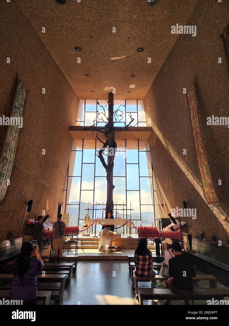 A group of people are gathered together in a room with a statue of ...