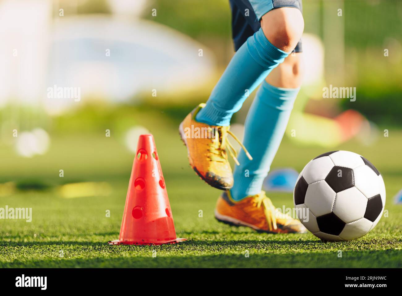 Legs of a soccer football player in blue socks and cleats running and ...