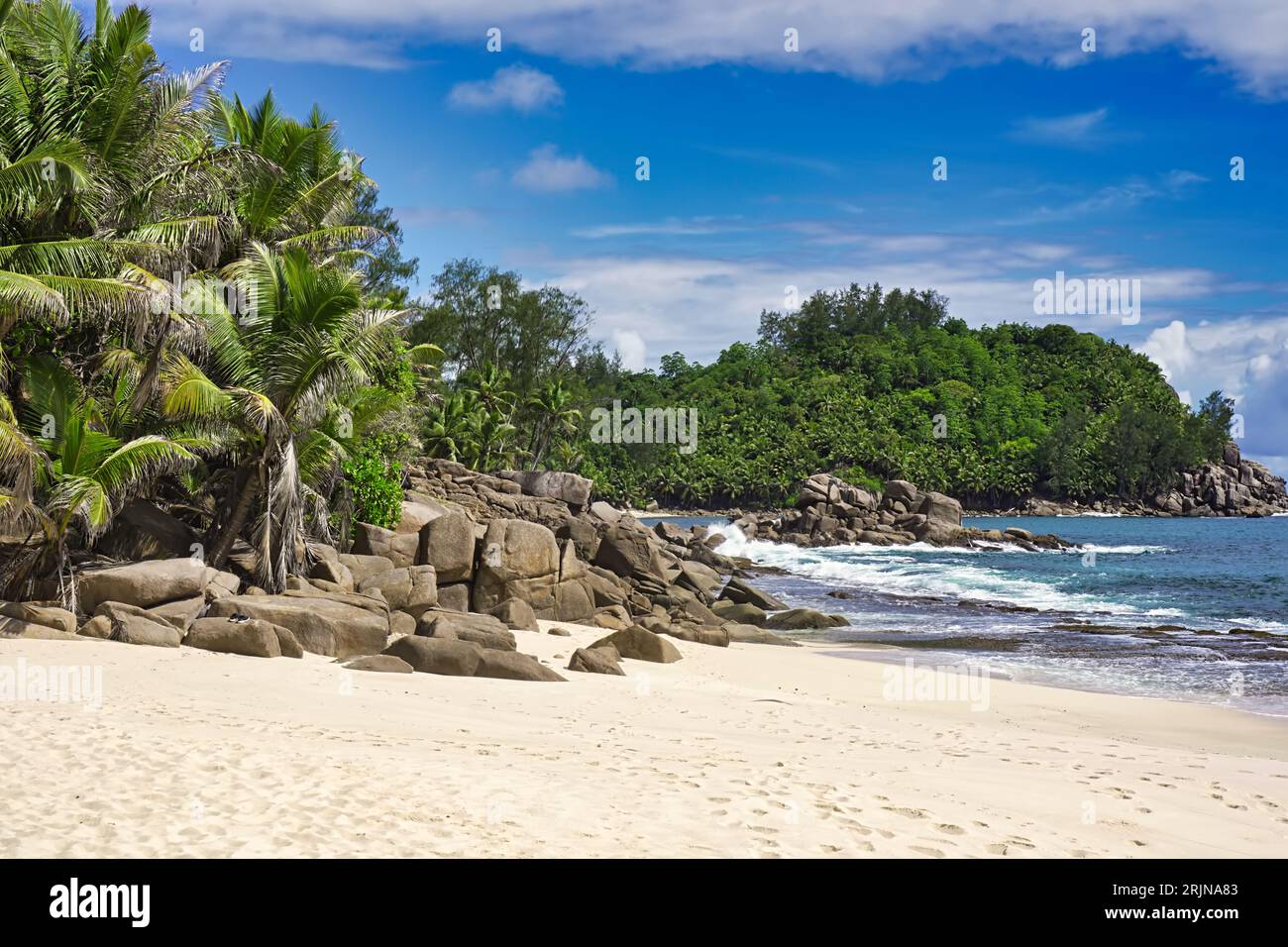 a pristine white sand beach on Mahe Island, Seychelles surrounded by ...