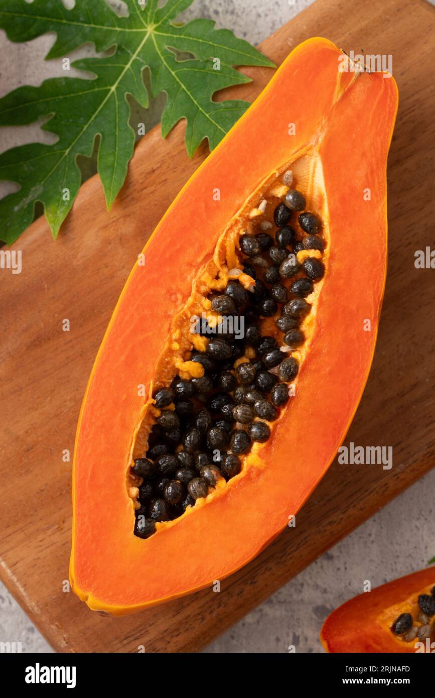 Cut Papaya over gray table background for tropical fruit design concept ...