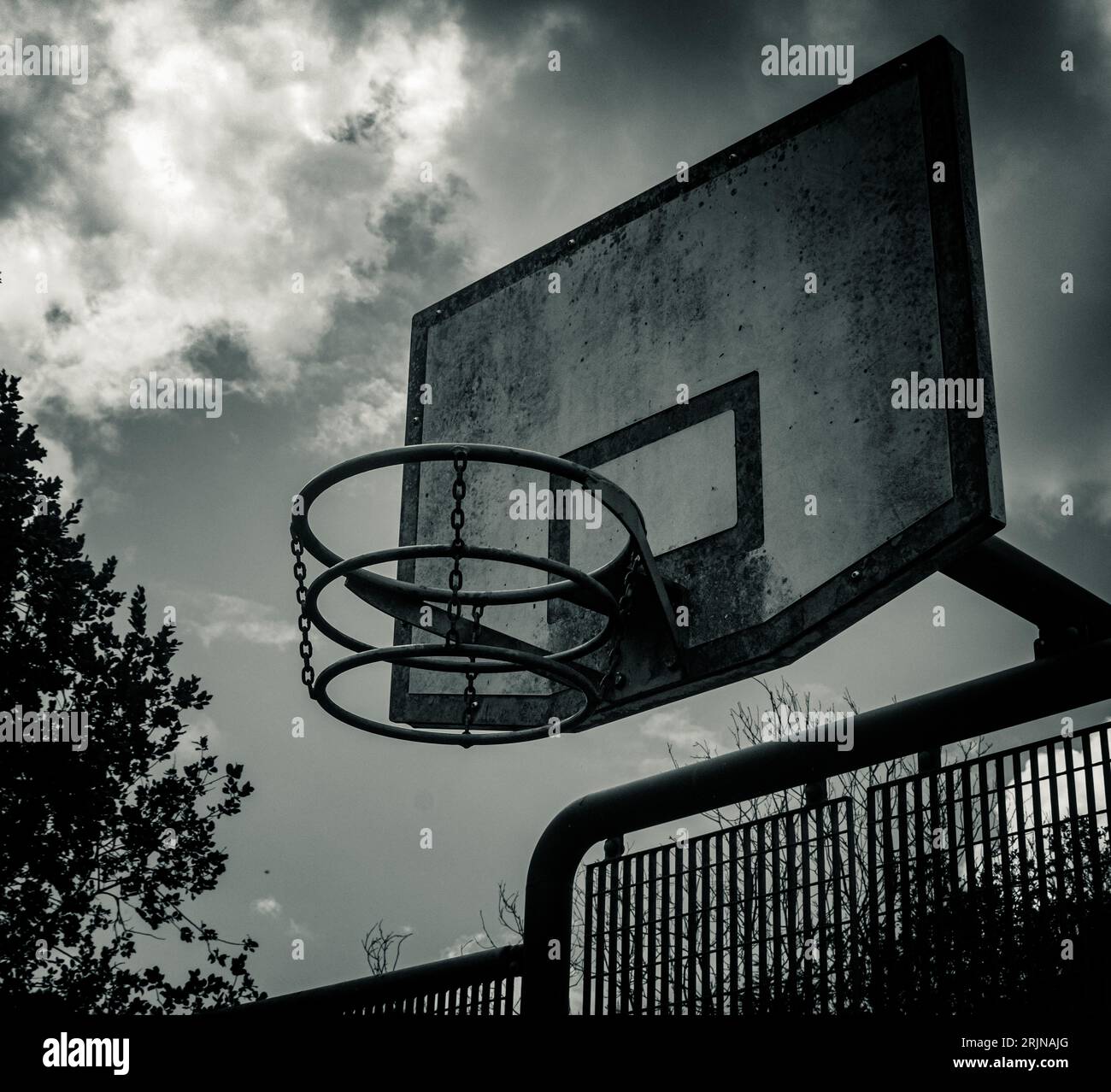 A grayscale of a basketball hoop on an empty playground Stock Photo - Alamy
