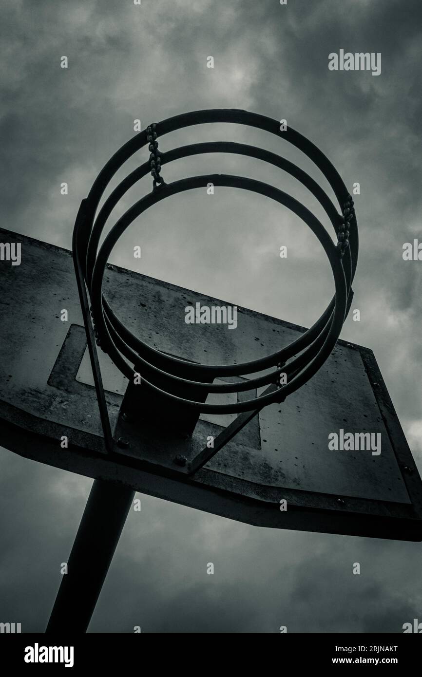 A grayscale of a basketball hoop on an empty playground Stock Photo - Alamy