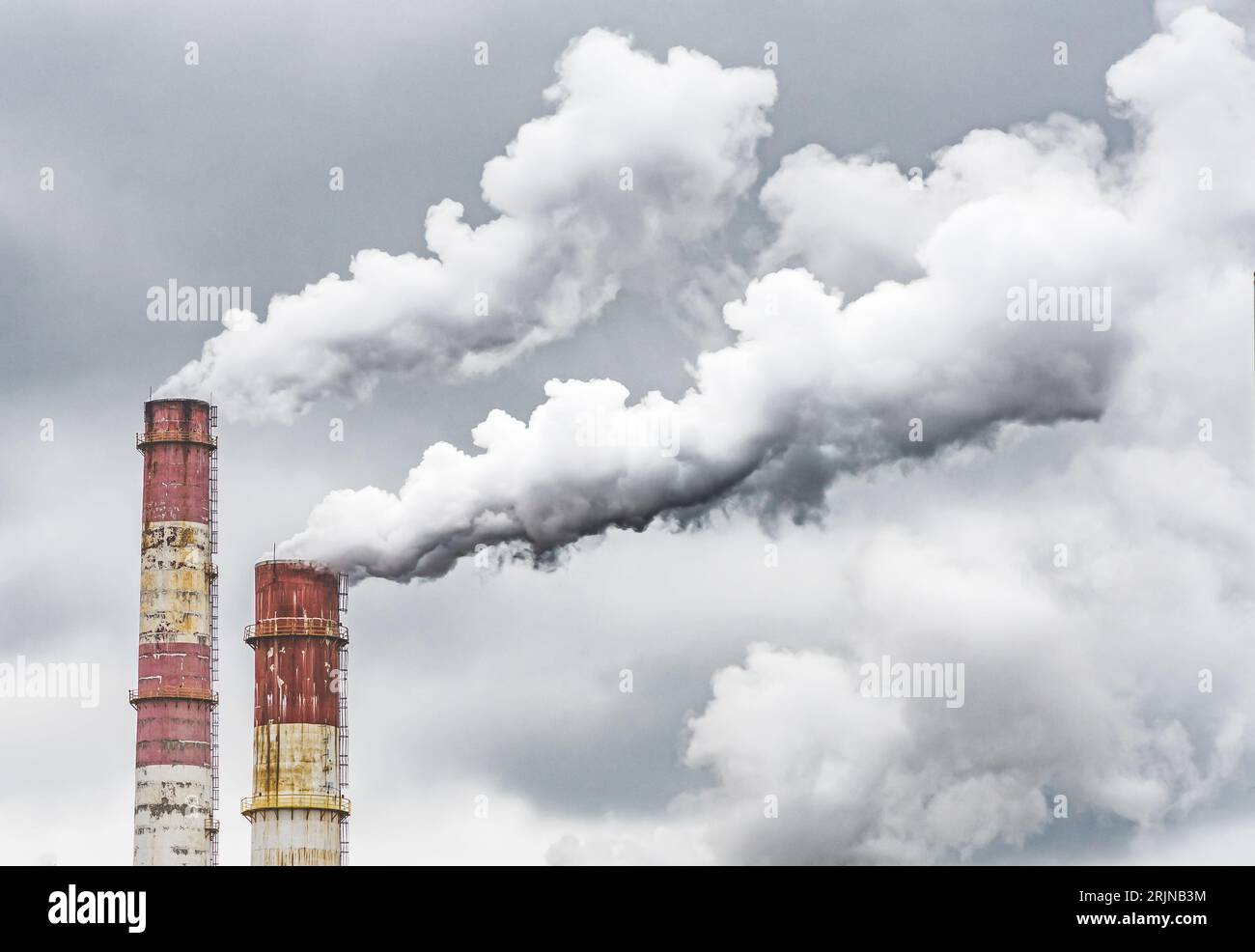 Thick white smoke from industrial factory old rusty chimneys on a ...