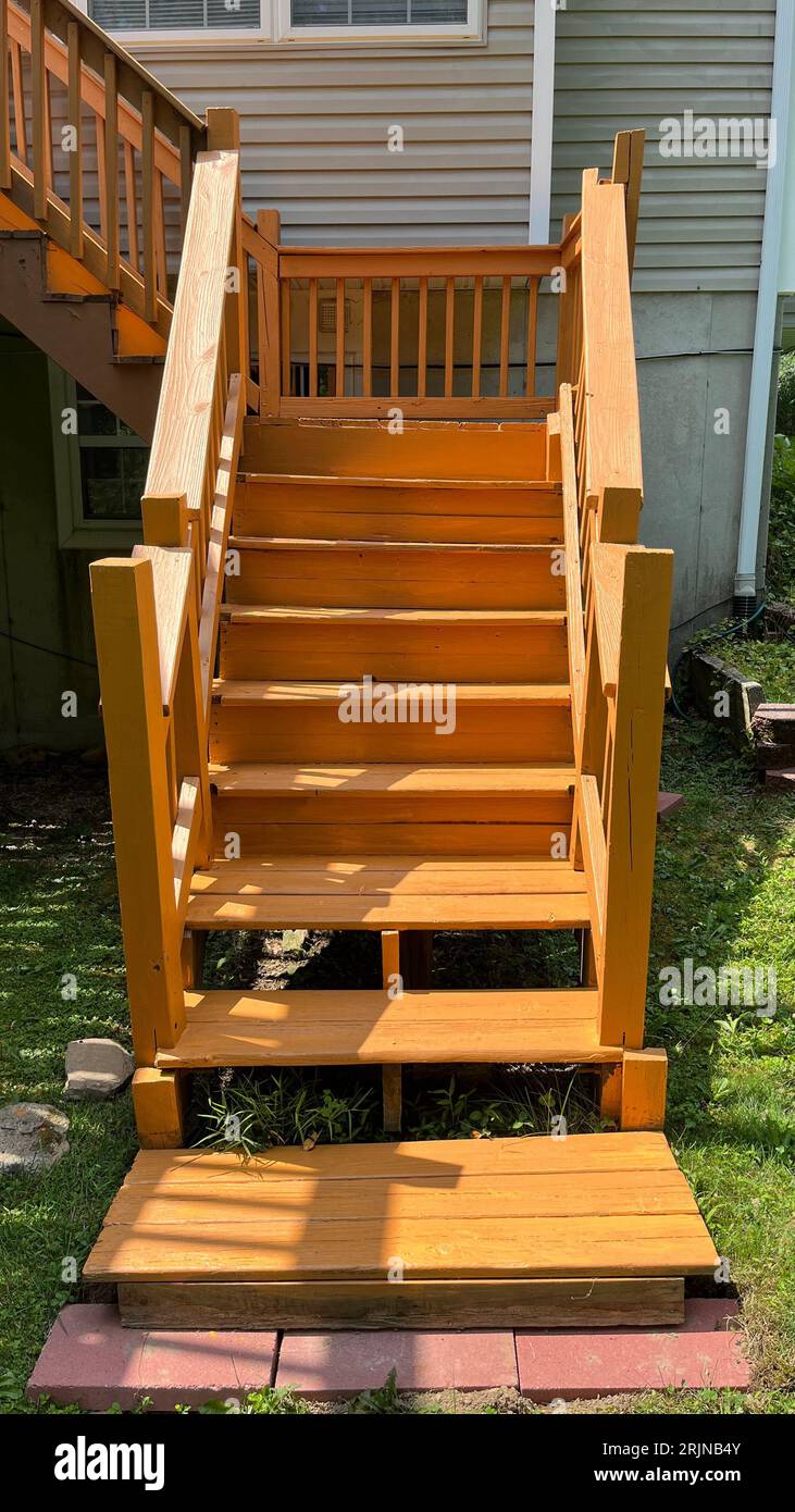 An outdoor wooden staircase leading up to a single-story home Stock ...