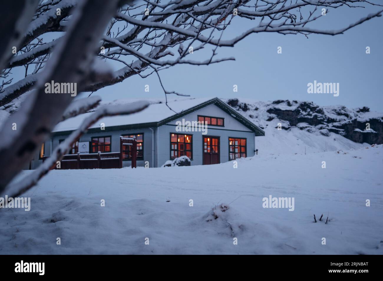 An idyllic winter scene is depicted, with a quaint house surrounded by ...