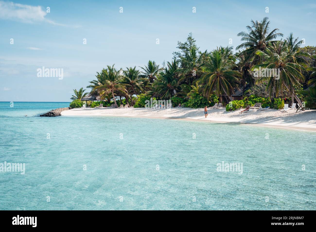 A stunning view of a beach in the Maldives featuring vibrant blue water ...