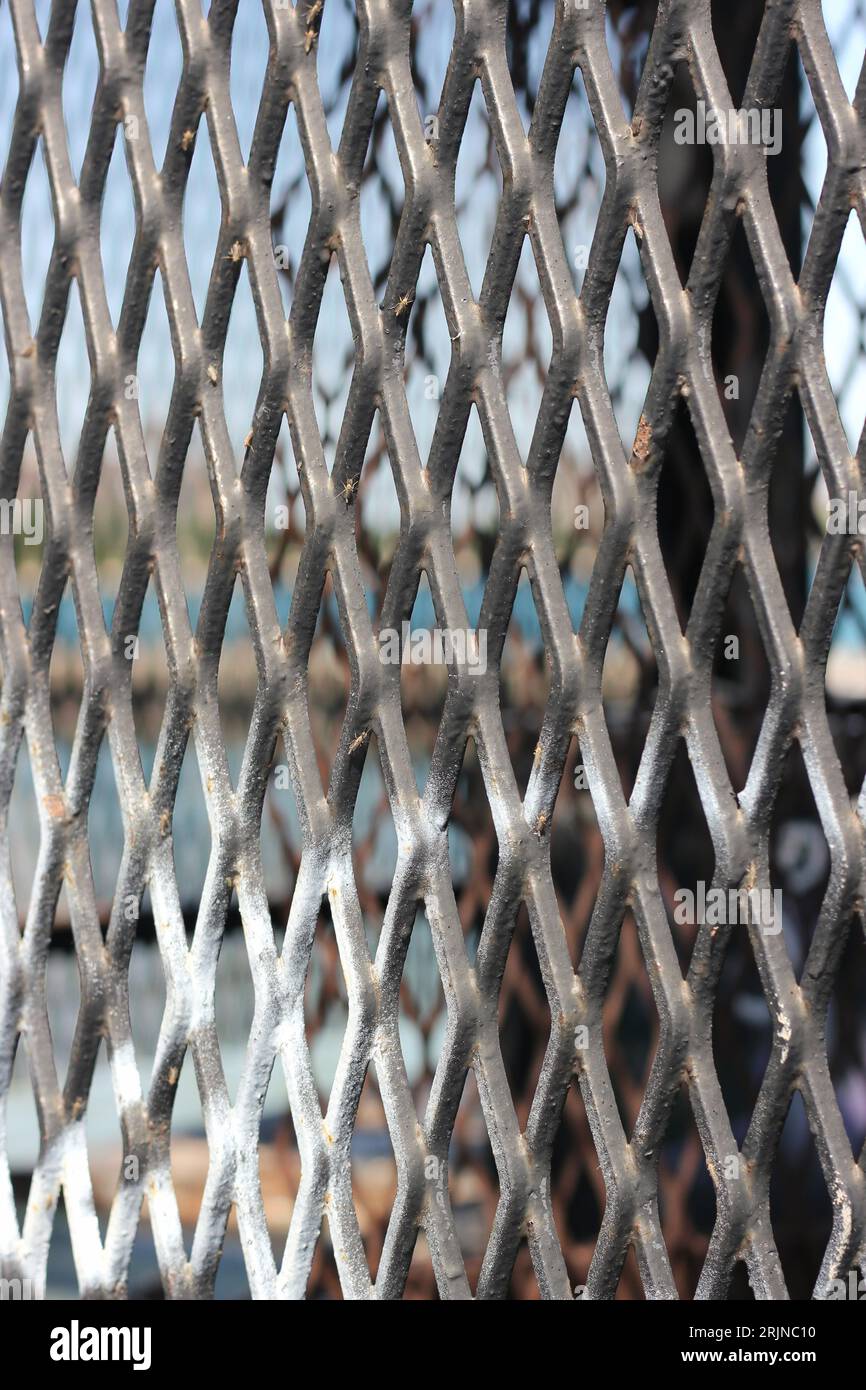 A common industrial chain link metal fence with a repeating pattern ...
