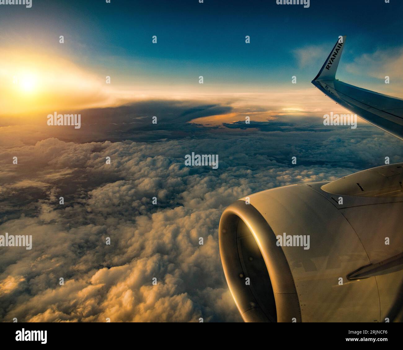 An aerial view of clouds at golden sunset seen from plane window Stock ...