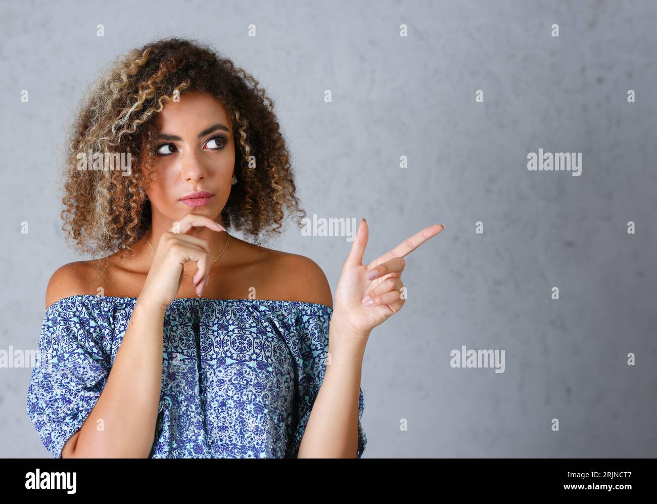 A black woman on a gray background points a finge Stock Photo - Alamy