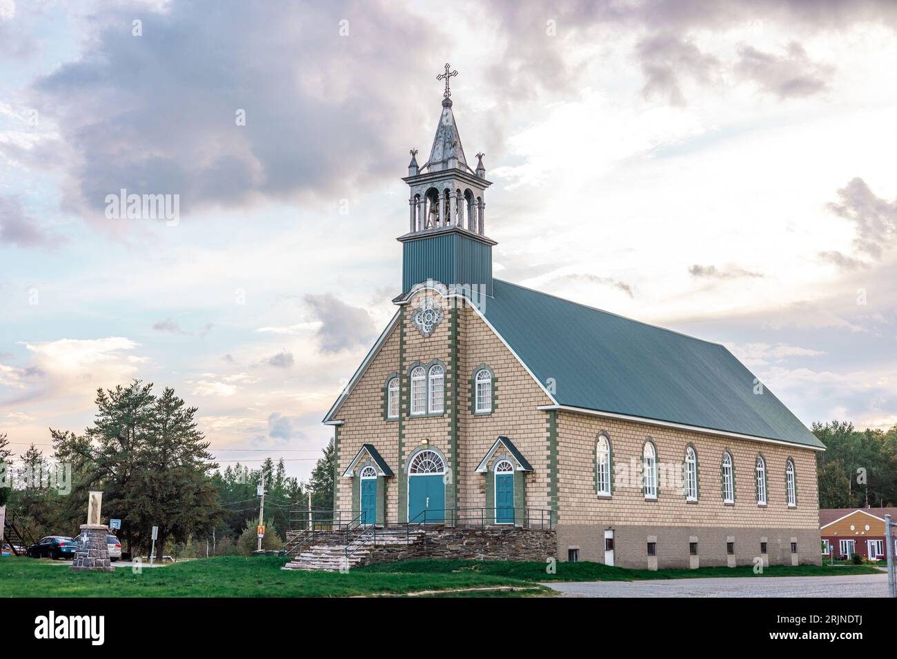 An aged wooden church with a bright green spire and multiple towers ...