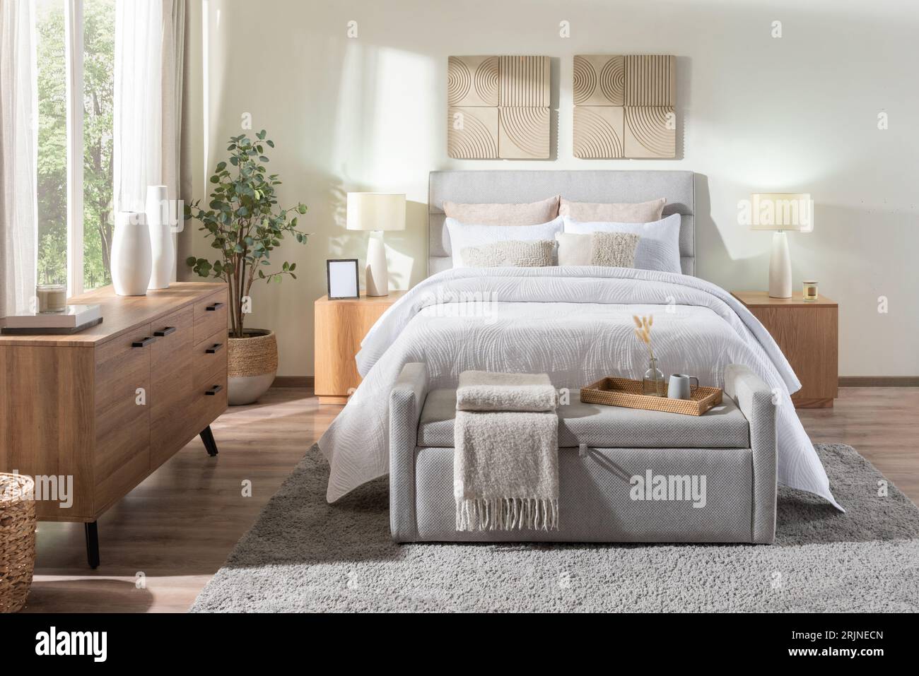 An interior bedroom scene featuring a bed, stool, and dressers Stock ...