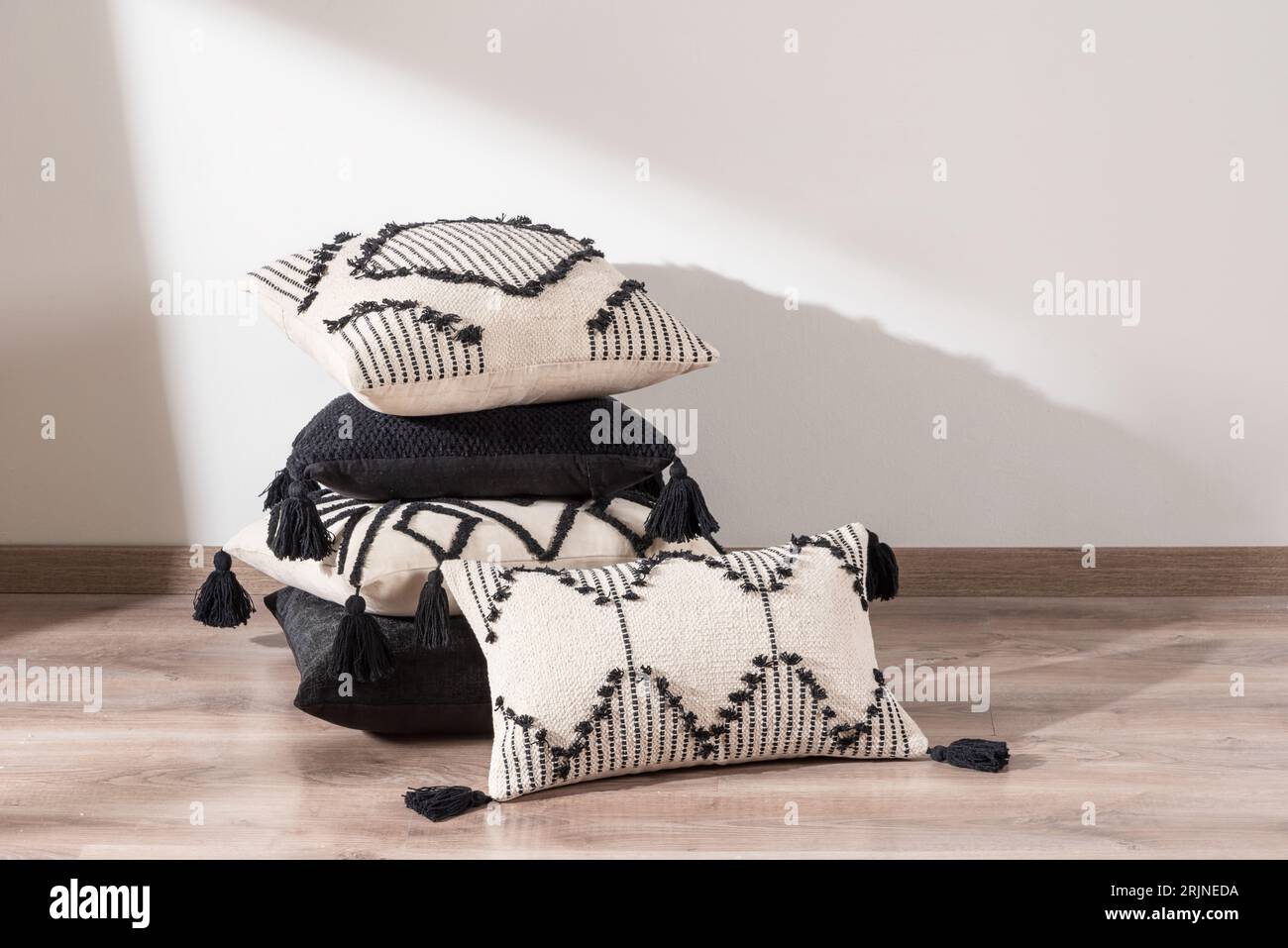 Two cushions of different shapes and colors are lying on the floor ...