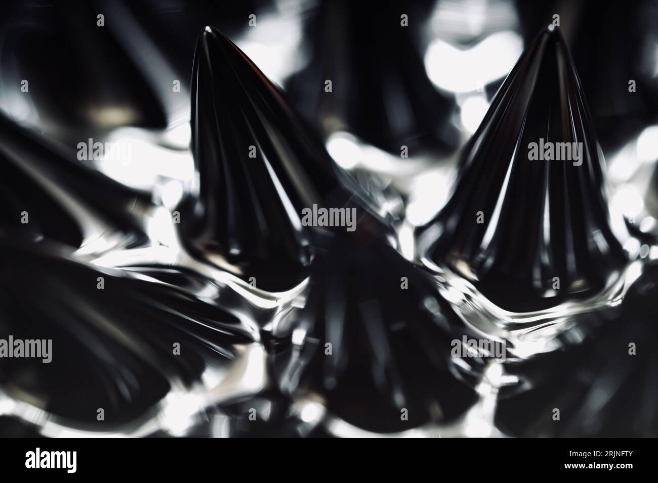 A macro close-up of ferrofluid reacting to a strong magnetic field ...