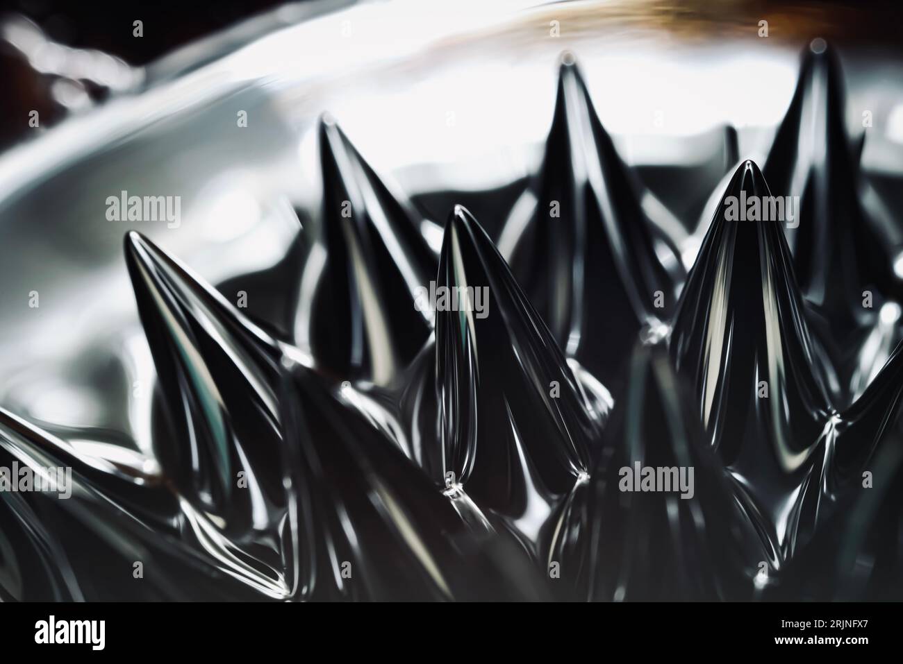 A macro close-up of ferrofluid reacting to a strong magnetic field ...