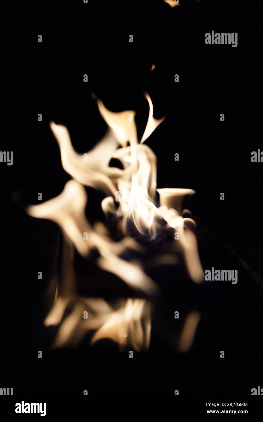 A high-resolution close-up of a bright orange and yellow fire burning ...