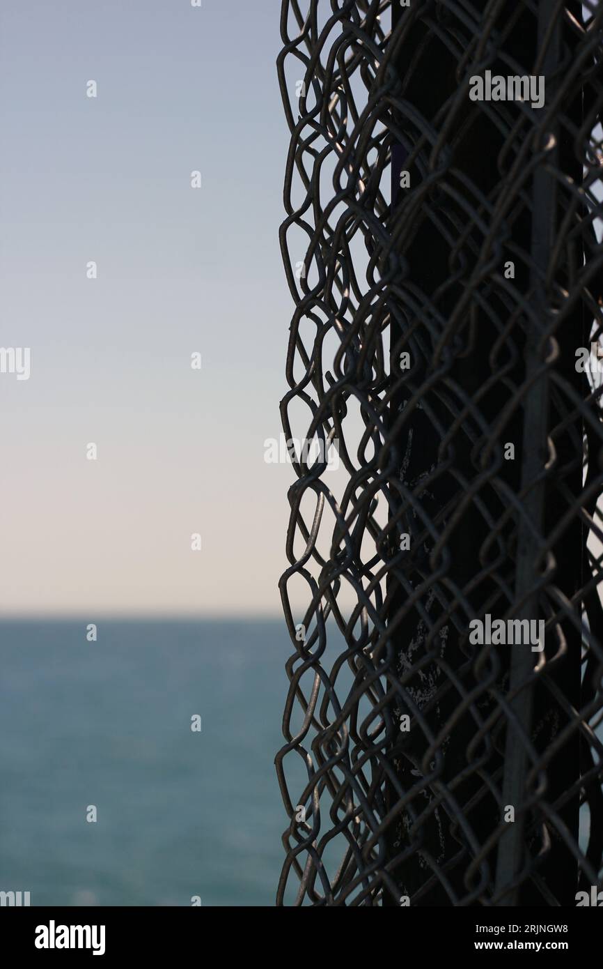 A common industrial chain link metal fence with a repeating pattern ...