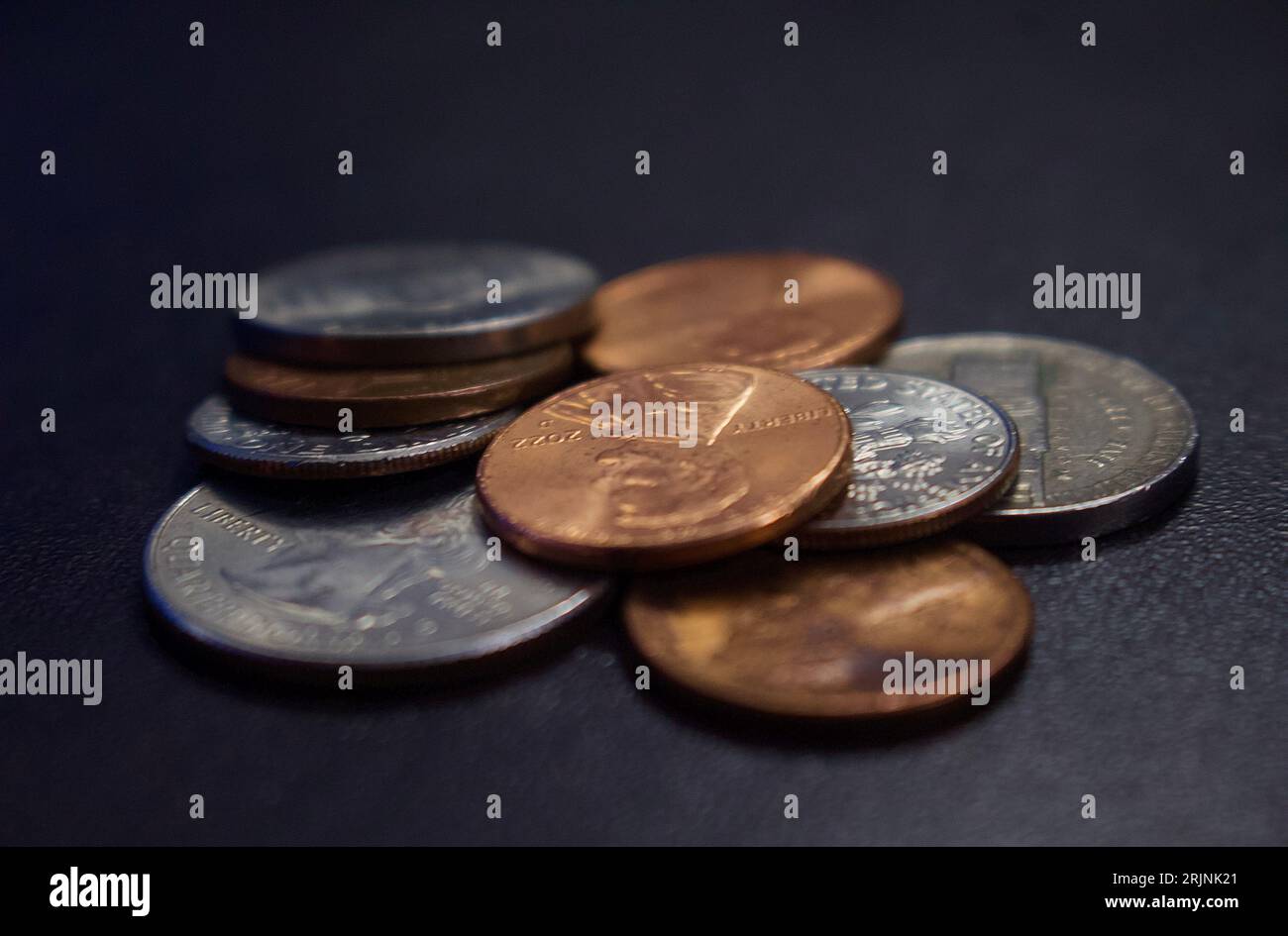 A pile of different coins of various sizes on a flat gray surface Stock ...