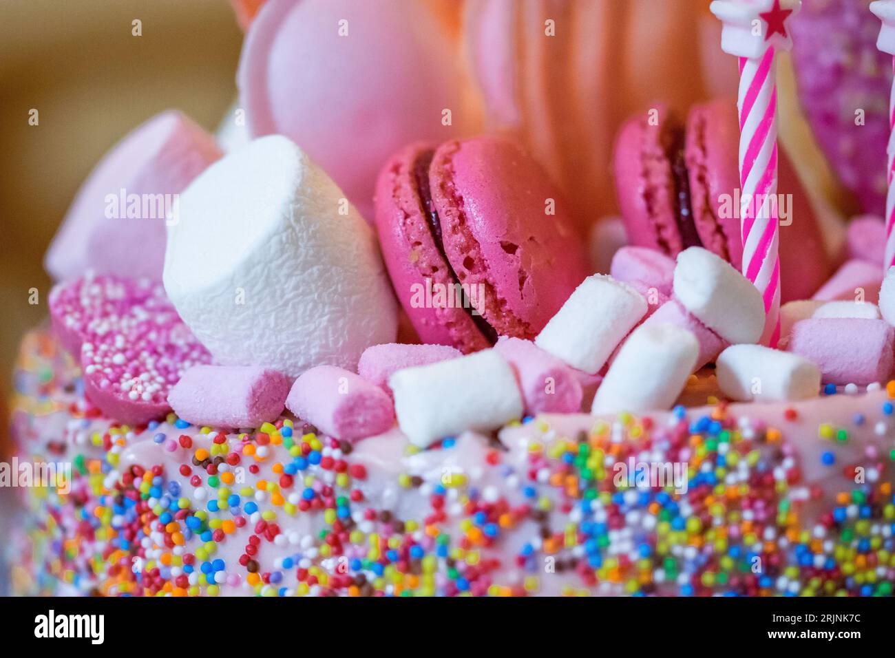 A pink-themed birthday cake, decorated with pink and white marshmallows ...