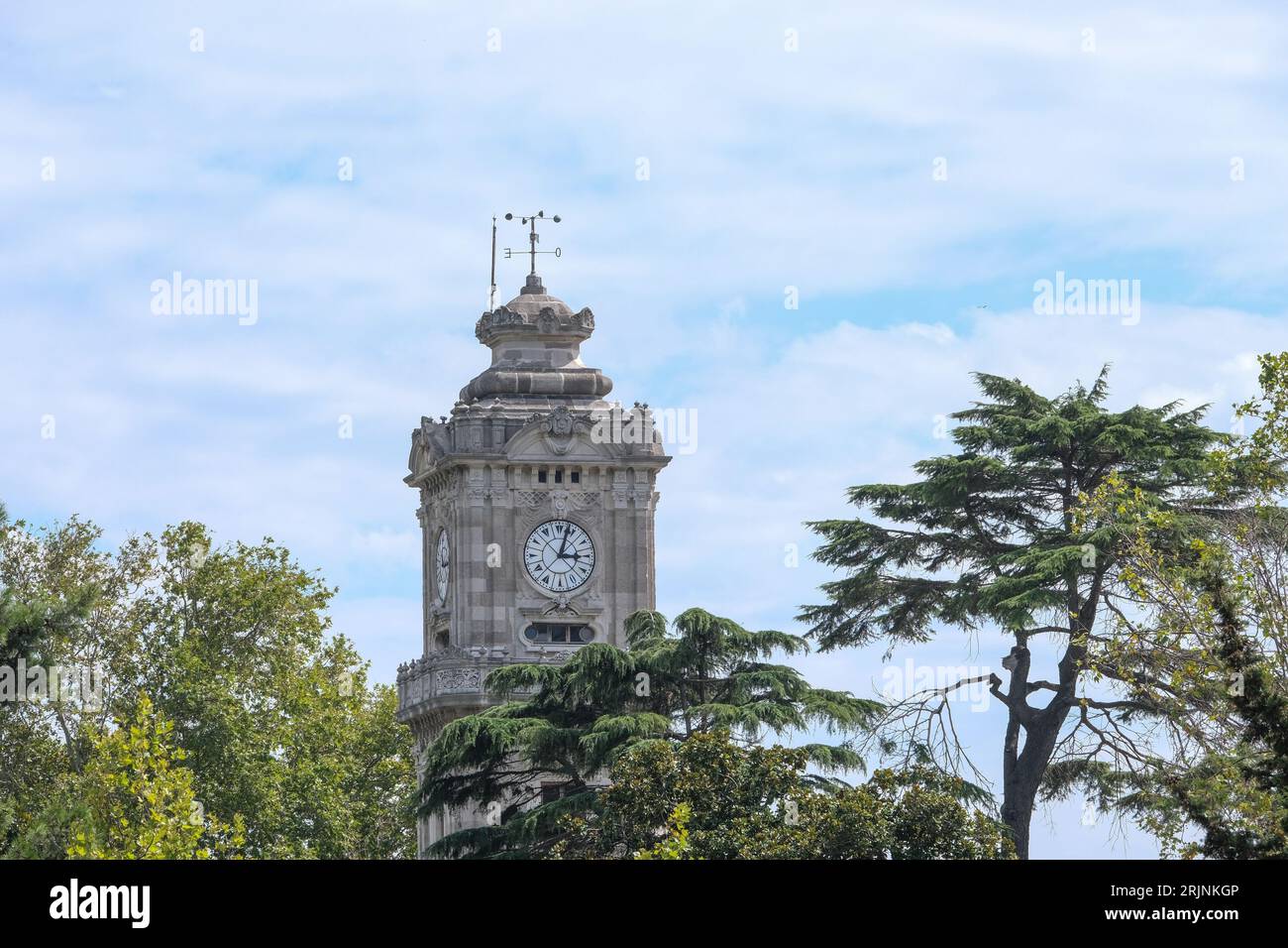 Dolmabahçe Palace clock tower with blue sky background and trees İn ...