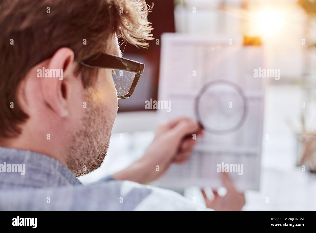 man looking through a magnifying glass to documents notebook Stock ...