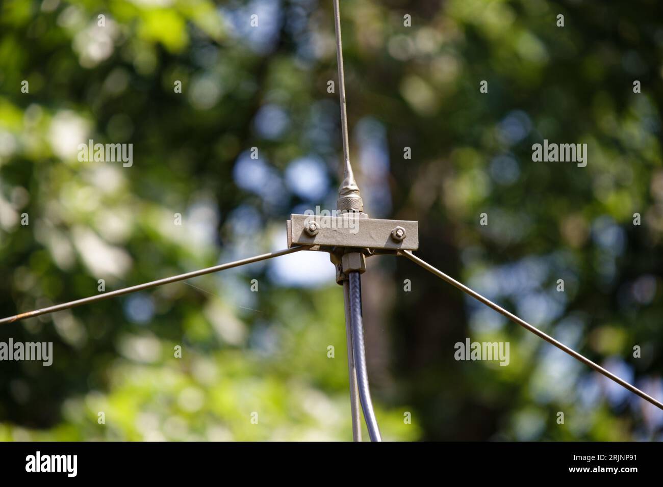A small antenna connected to a metal pole via two wires, mounted in an ...