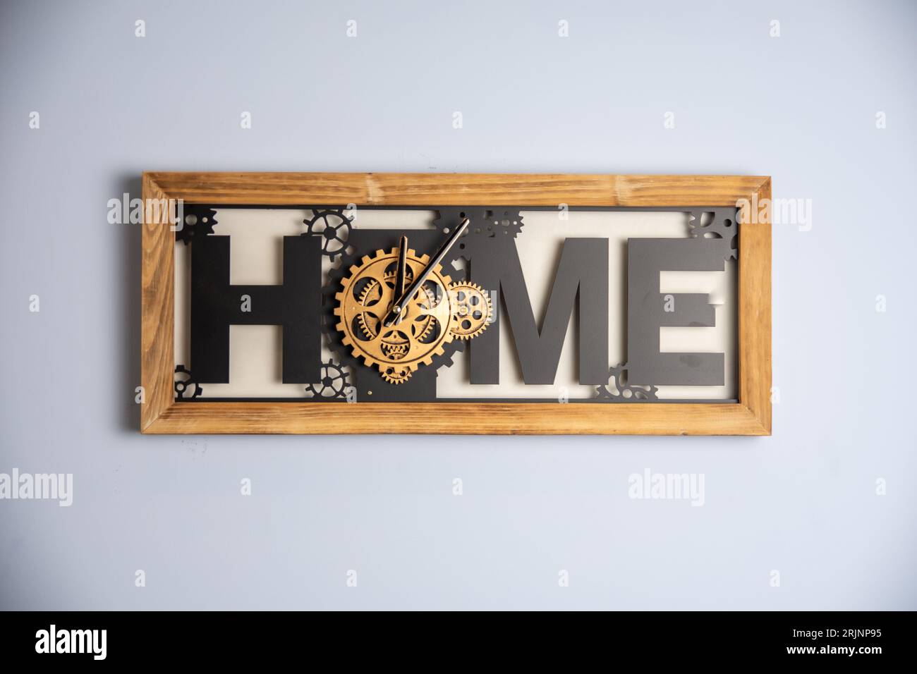 This image features a wooden wall clock with the word Home inscribed on ...