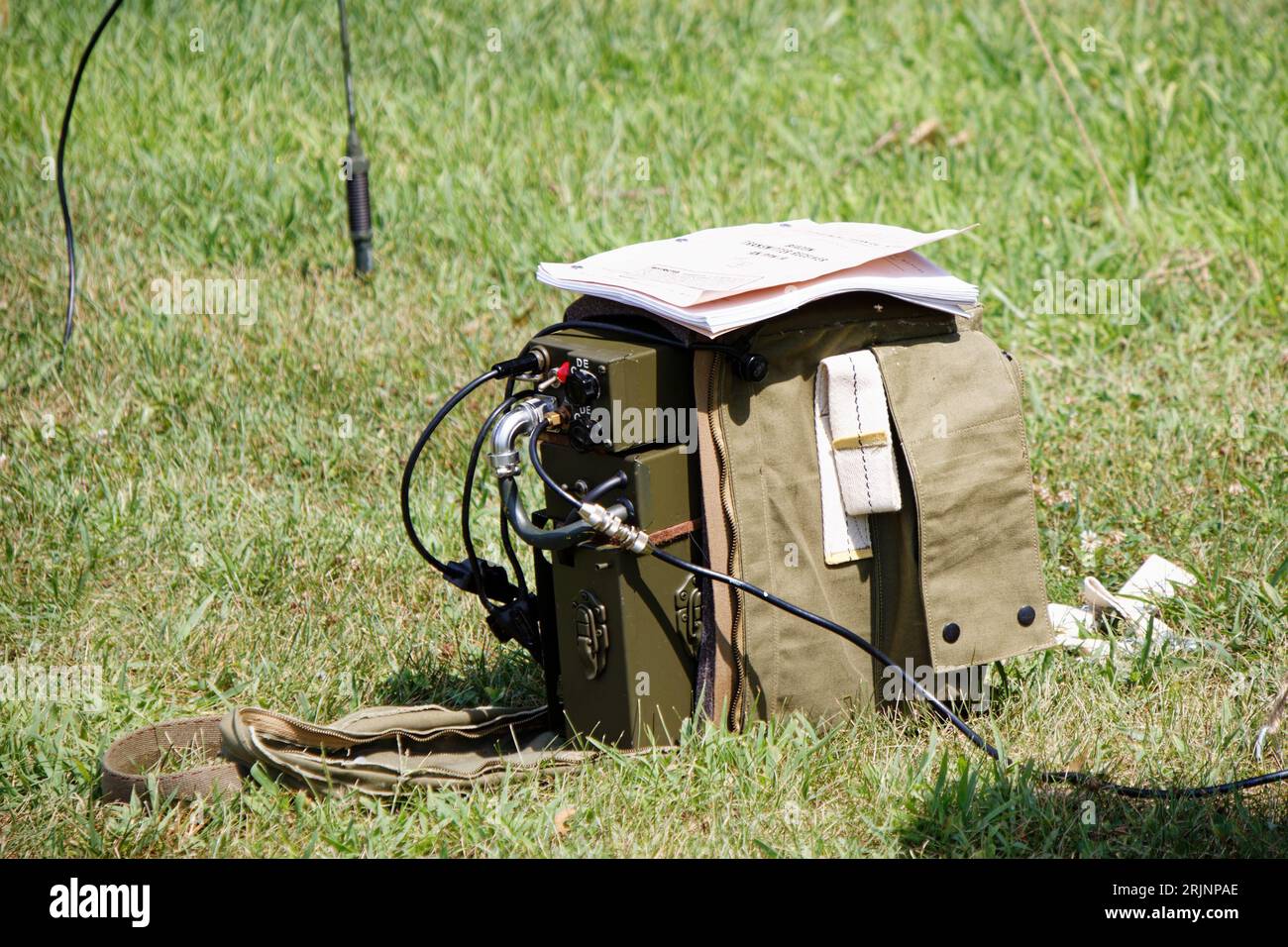 An old military device on its side in a grassy field, with its ...