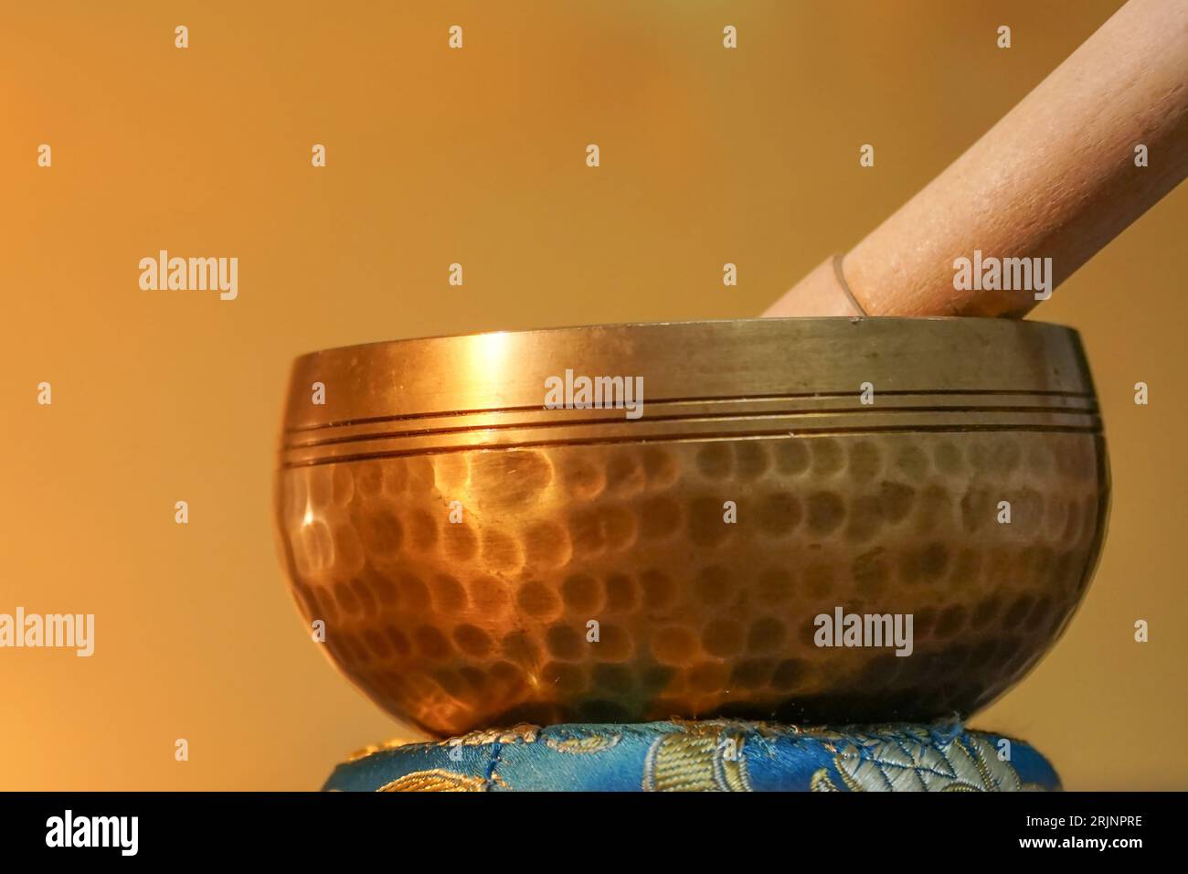 An ornate, hand-hammered Tibetan bell on a golden background Stock ...