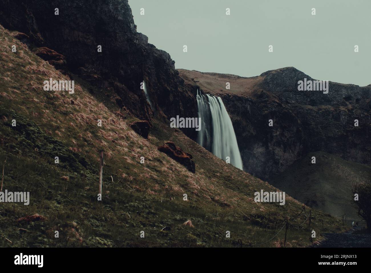 An idyllic scene showing a powerful waterfall cascading down the face ...