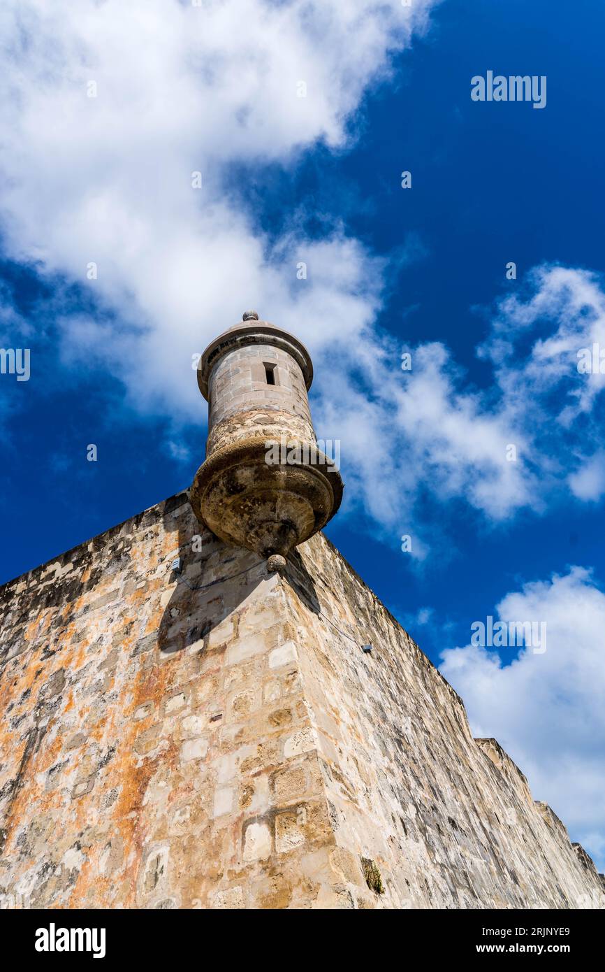 A tall brick lighthouse stands atop a steep cliff, reaching high into ...