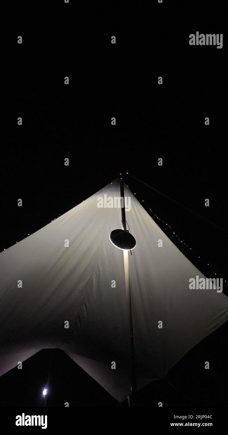 A bright and colorful tent canopy lit up against a dark night sky Stock ...