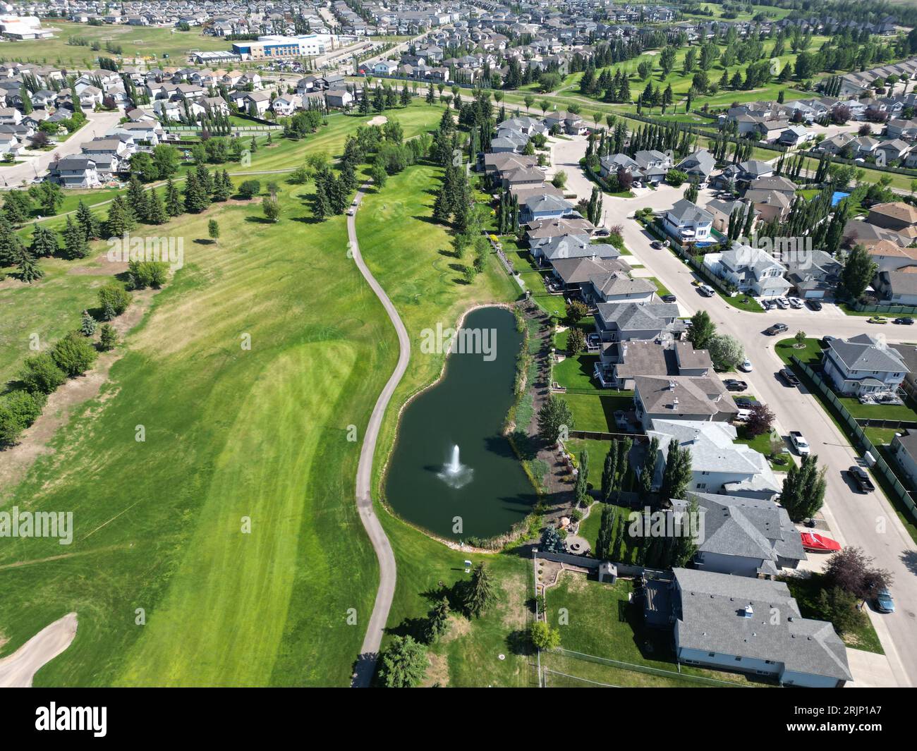 An aerial view of a pristine golf course, featuring lush green grass, a ...
