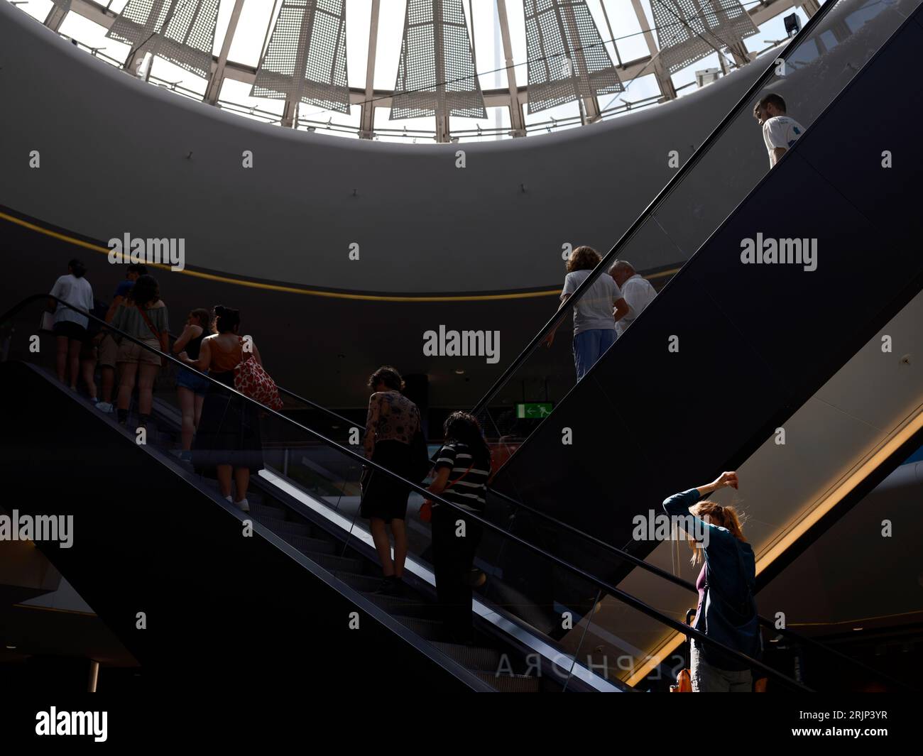 People take the escalator in a shopping mall during a heat wave in Lyon ...
