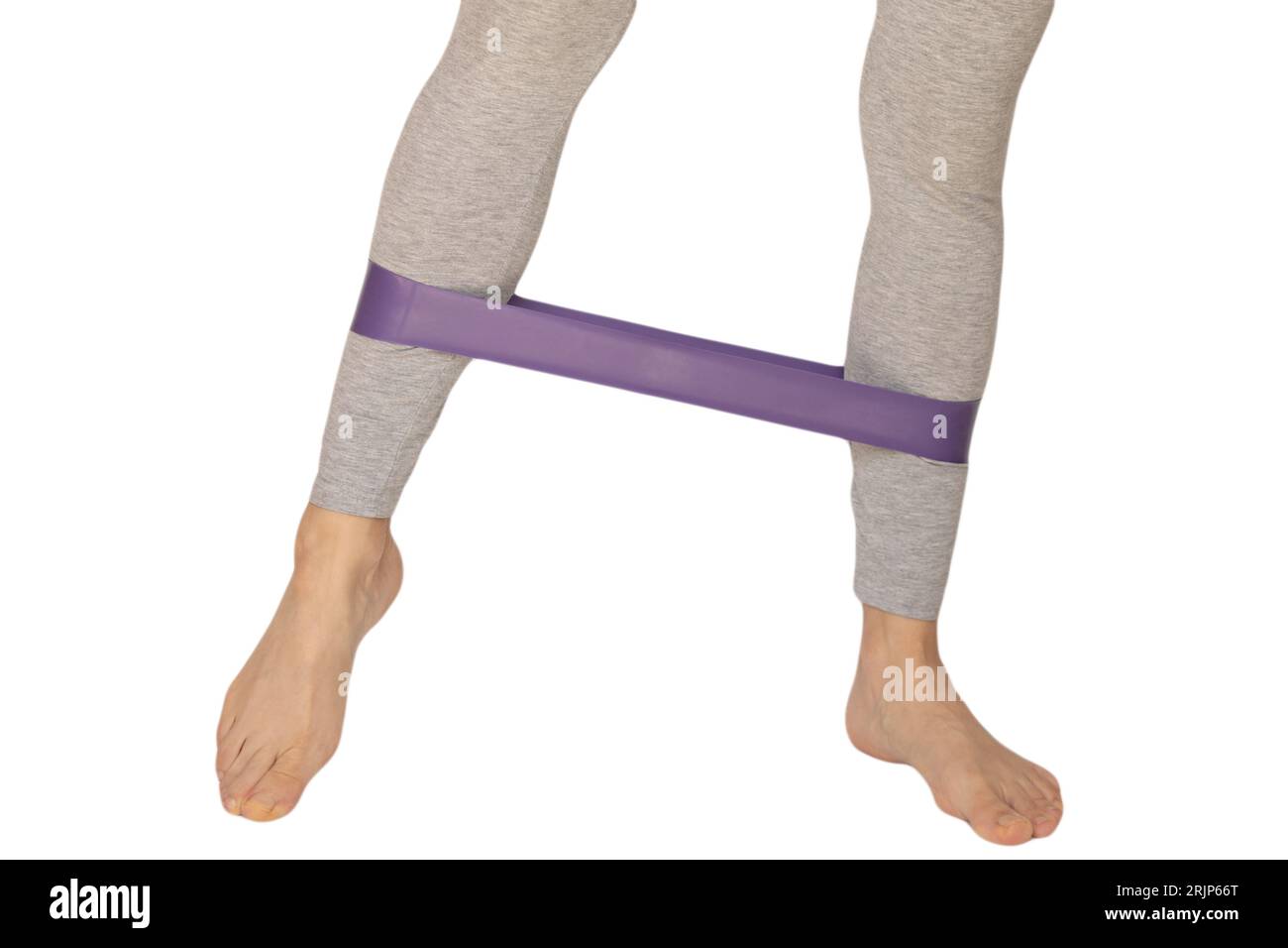 The girl is engaged in fitness with a fitness elastic band on a white ...