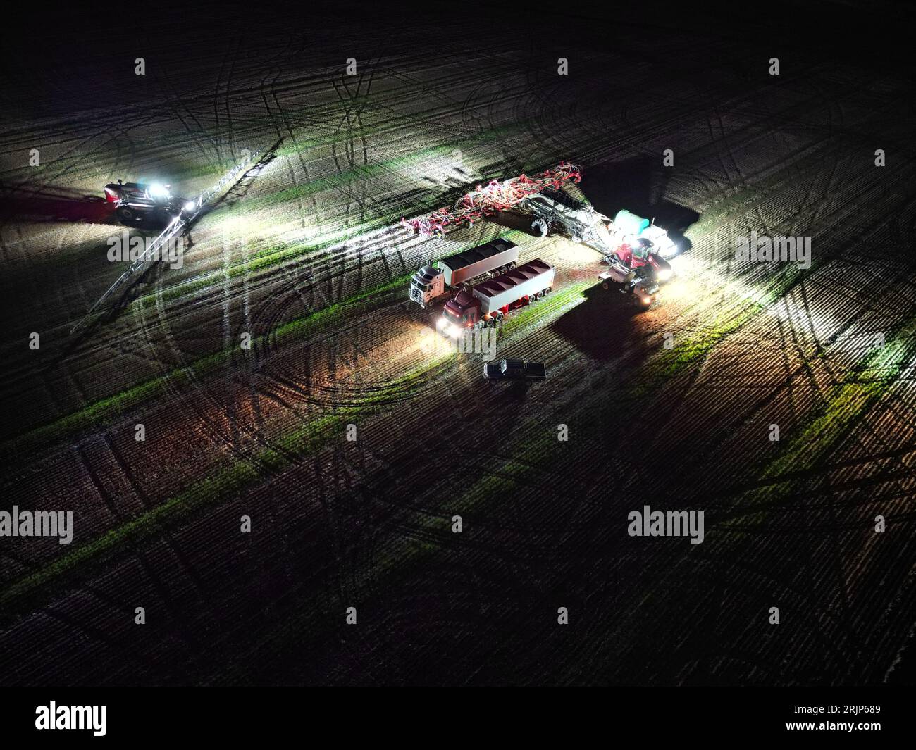 An aerial view of a farm with agricultural tractors scattered across ...