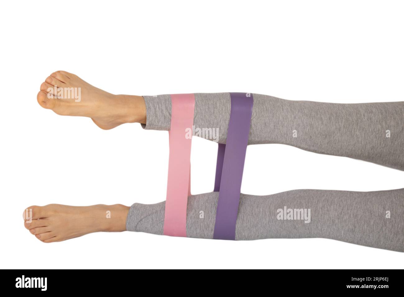 The girl is engaged in fitness with a fitness elastic band on a white ...
