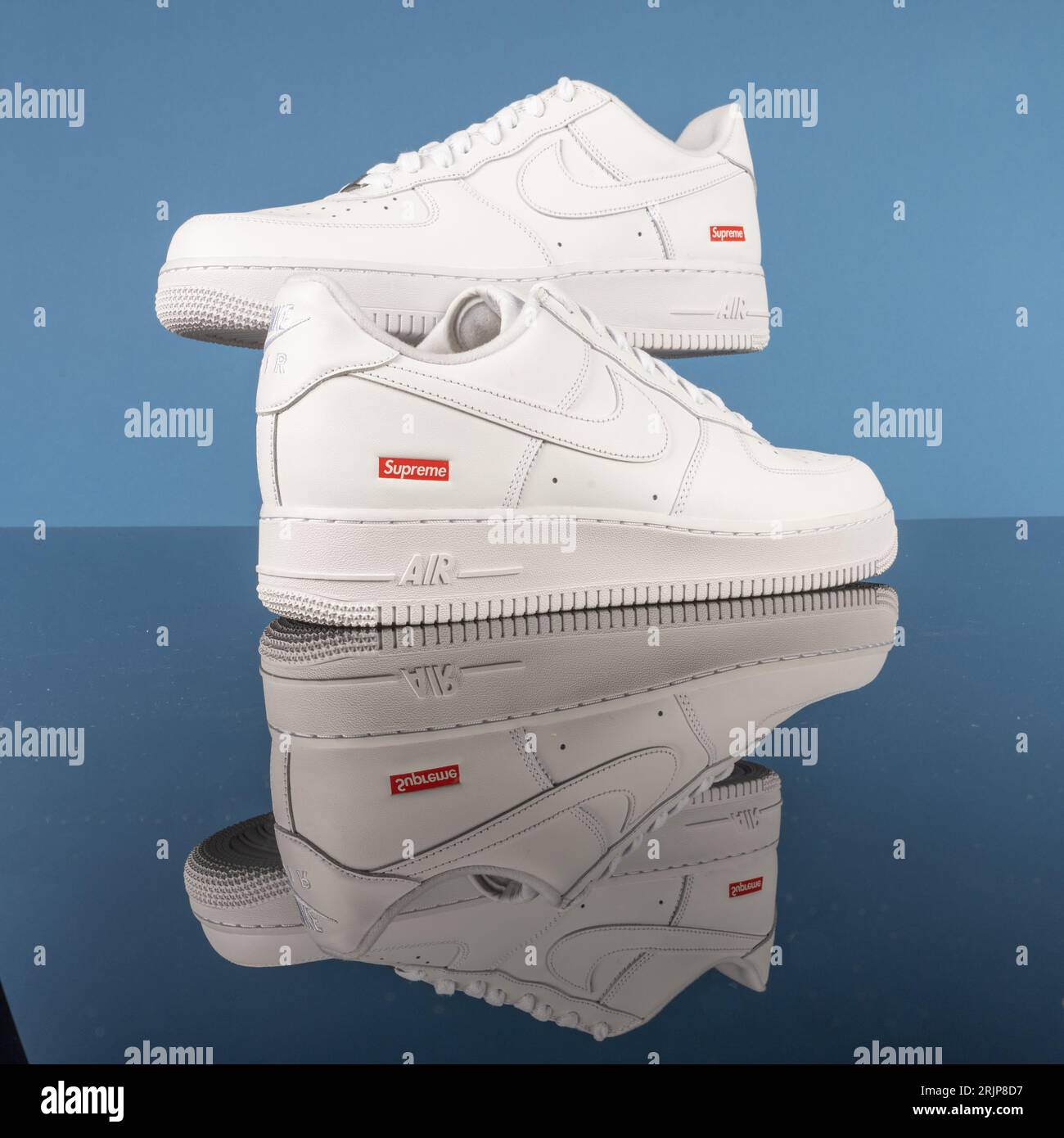 A pair of Nike Air Force Supreme larger sneakers on a reflective ...