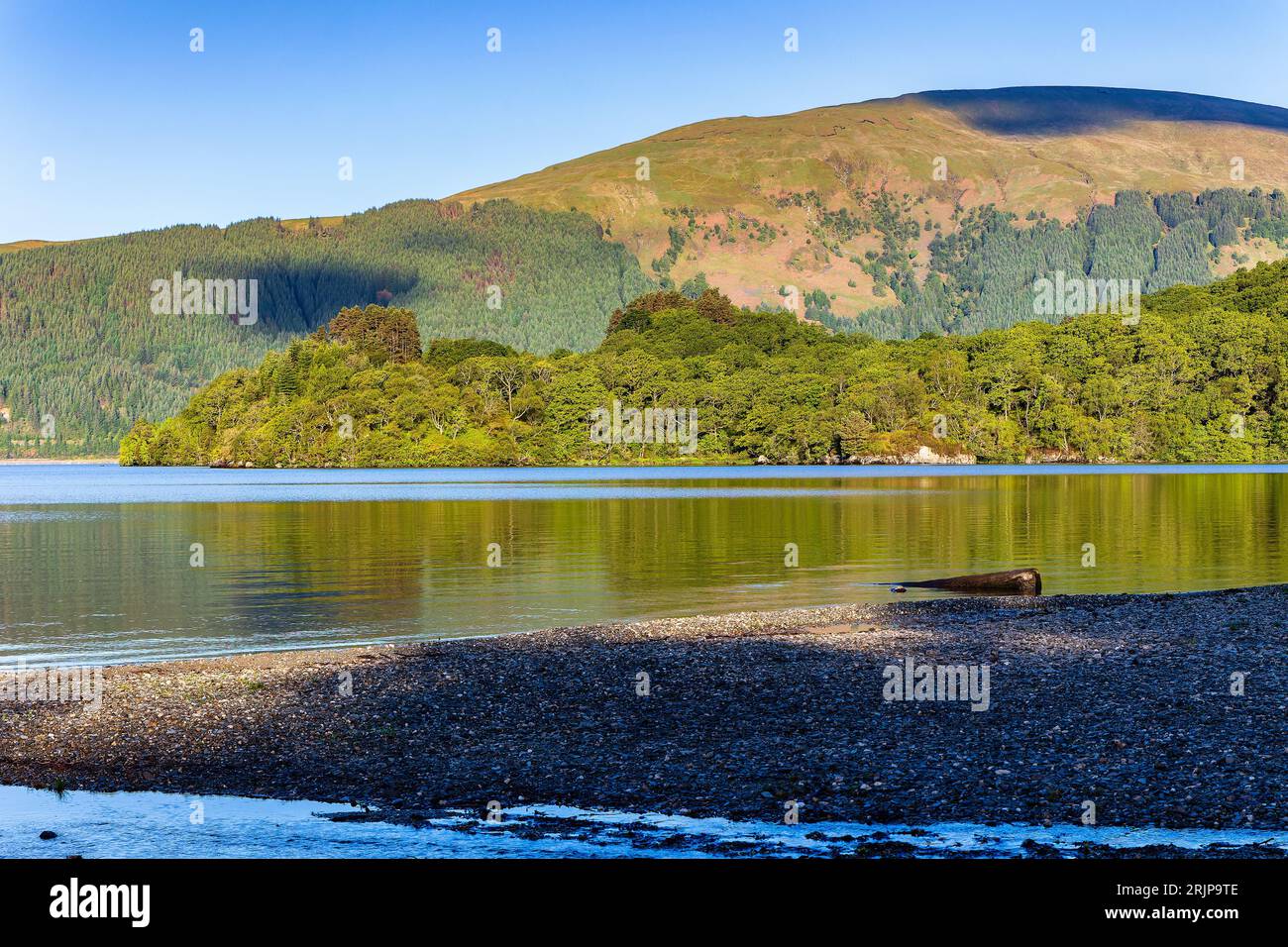 A peaceful loch surrounded by dramatic mountains hi-res stock ...