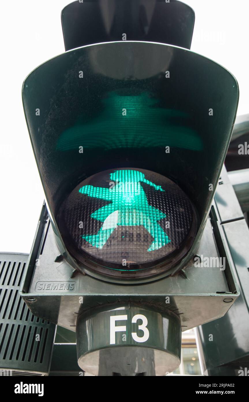 A green traffic light illuminates a pedestrian crossing, clearly ...