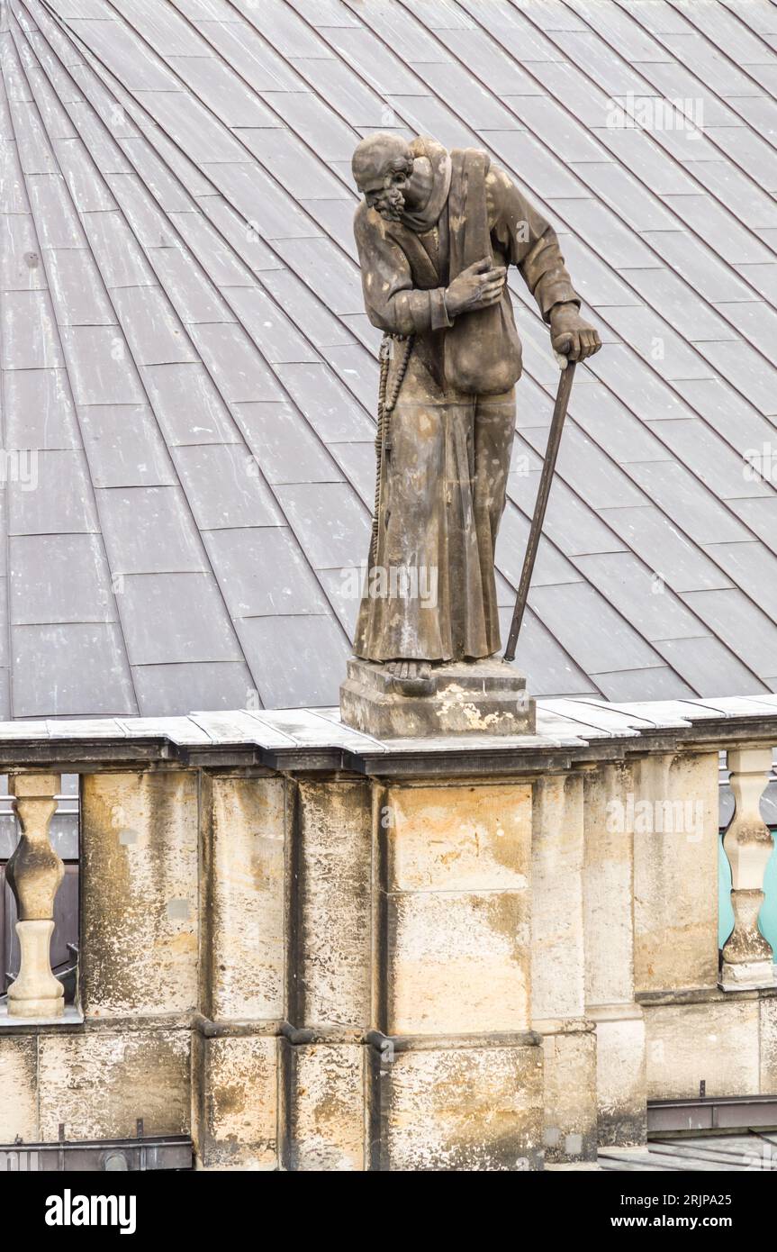 An adult male figure statue standing atop a rooftop posed in a heroic ...