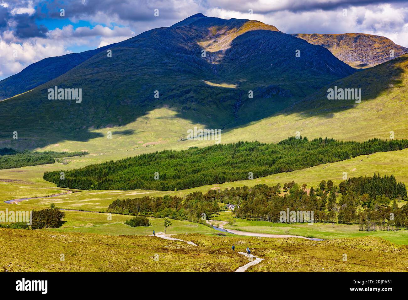 Hikers heading towards a distant mountain in spectacular rural scenery ...