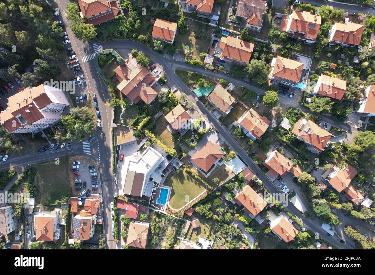 An aerial view of a residential area with multiple homes, vehicles ...