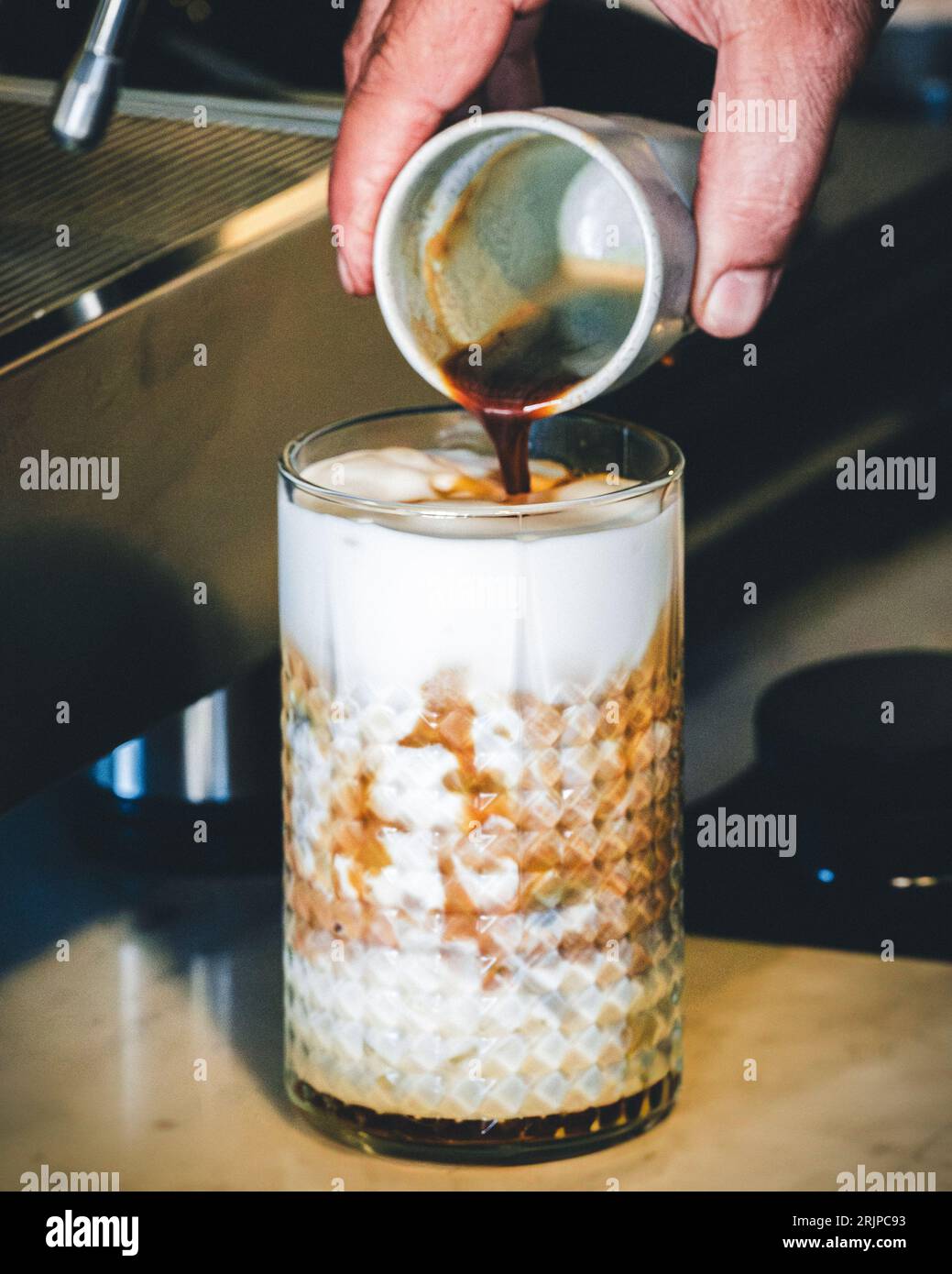 A human hand pouring freshly brewed coffee into a glass Stock Photo - Alamy