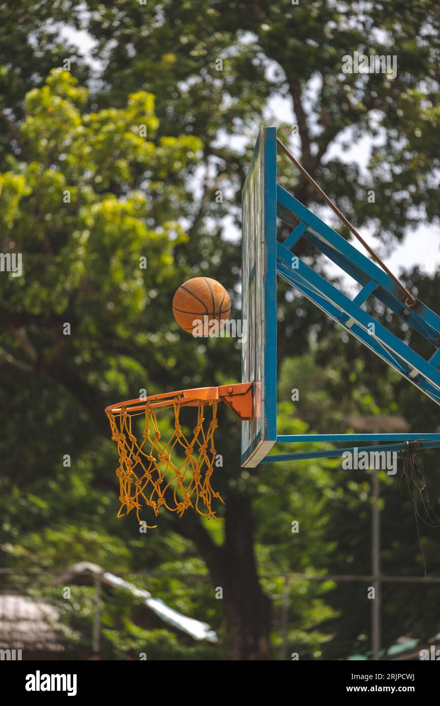 A basketball in the process of falling into the hoop Stock Photo - Alamy