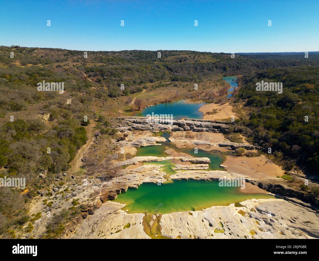 An aerial view of green and blue lakes in Pedernales State Park in ...