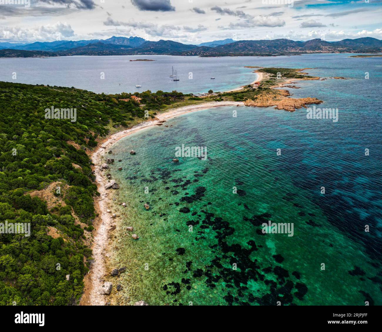 A stunning aerial view of a lush green forested island surrounded by an ...
