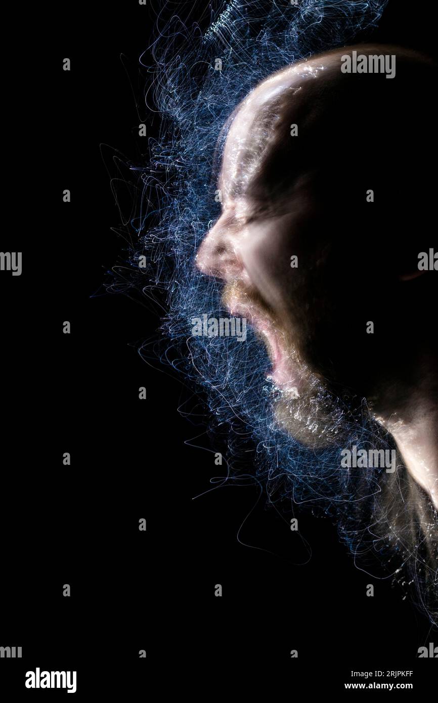 artistic portrait of a person screaming in motion with lights creating ...