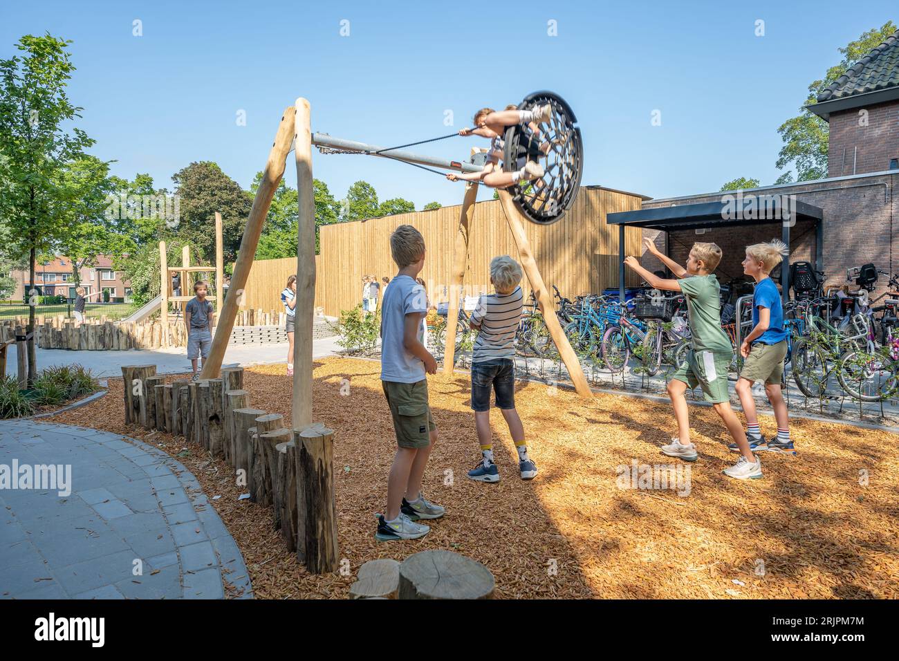 A group of children of varying ages enjoying themselves at a playground ...