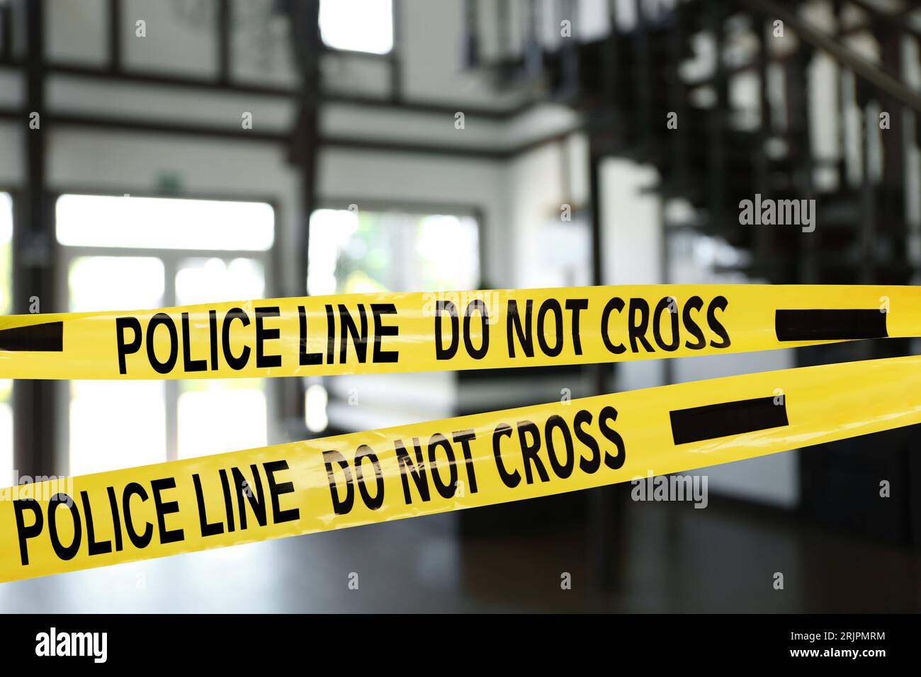 Yellow crime scene tape blocking way indoors Stock Photo - Alamy