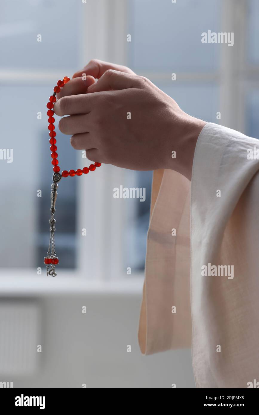 Muslim man with misbaha praying near window indoors, closeup Stock ...